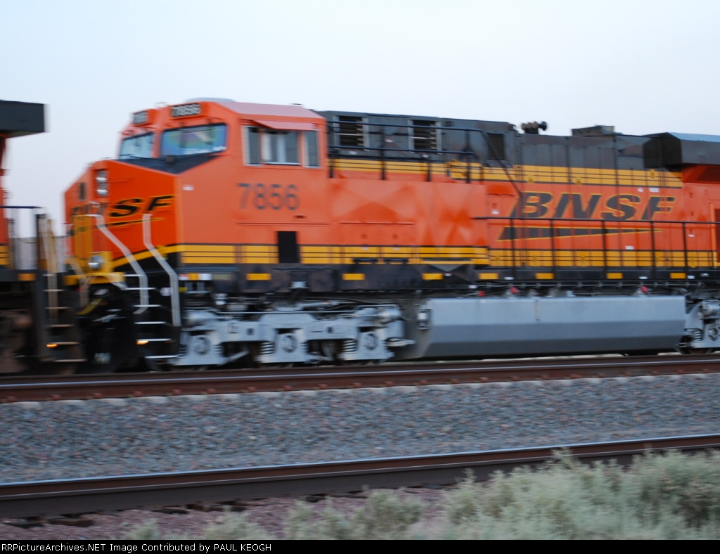 BNSF 7856 Blurs the camera lens as she rolls west.